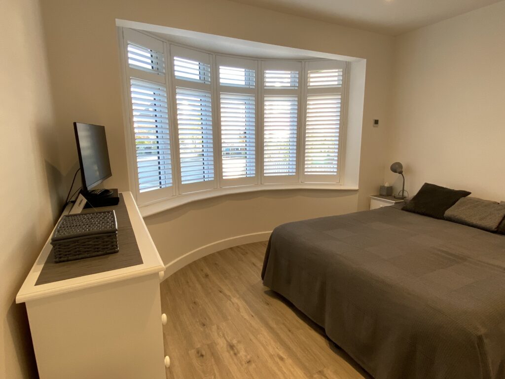 Curved Bay Windows Transformed with Wooden Shutters in Hampton